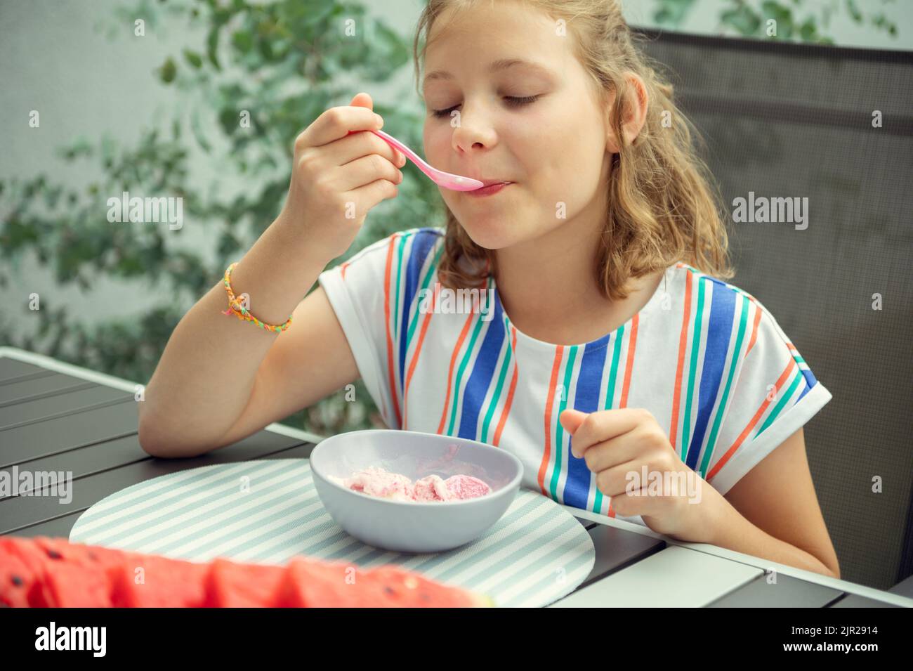 Cute teen girl enjoying eating ice-cream at outdoor cafe Stock Photo ...