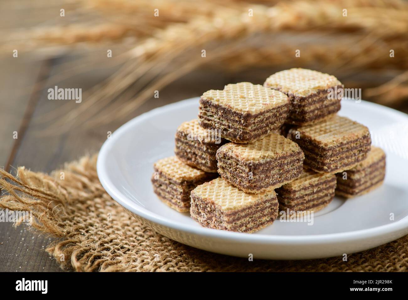 square chocolate wafer biscuits in white dish with flower barley ...
