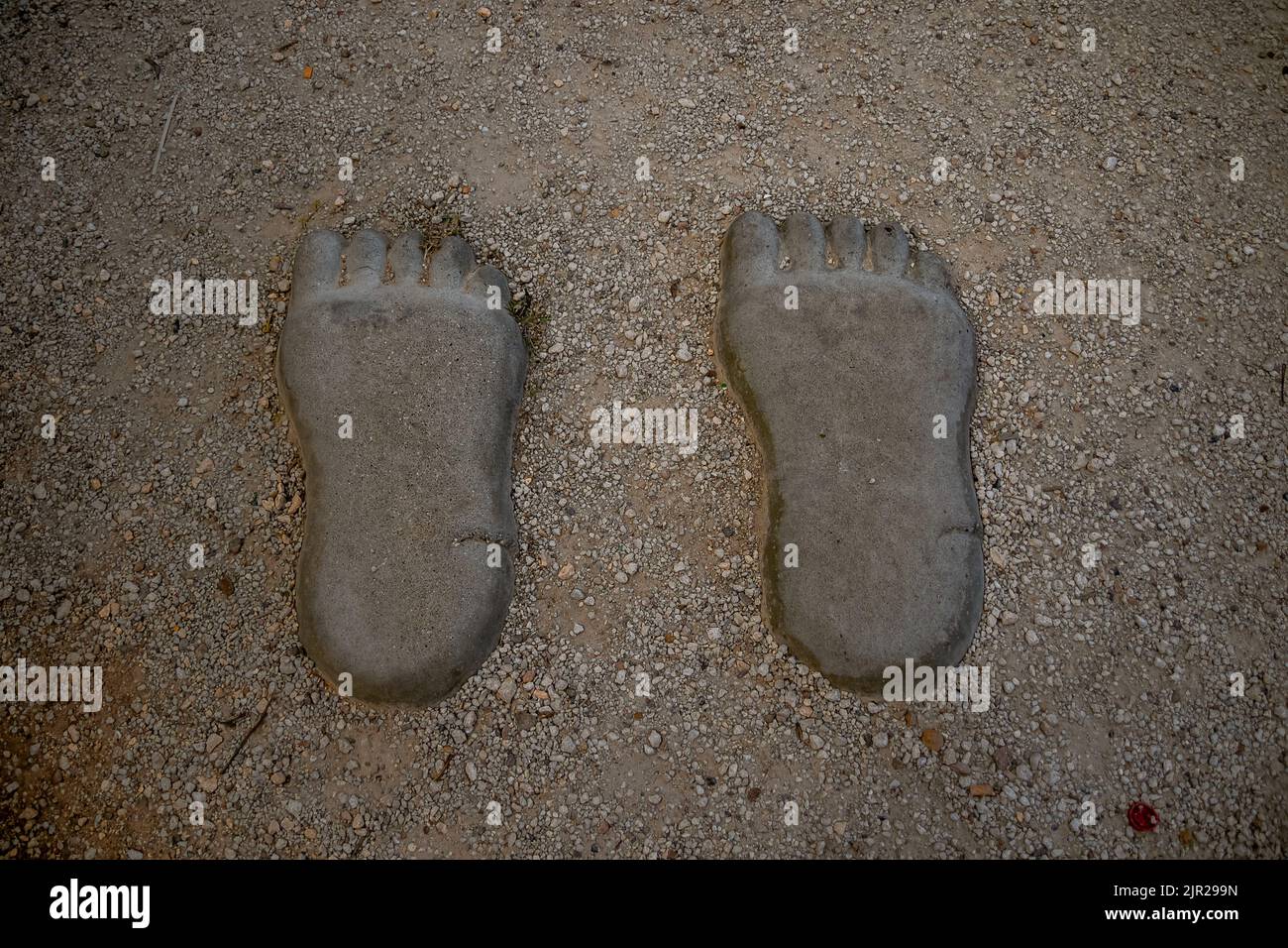 A closeup of two feet shaped stepping stones on a beach Stock Photo - Alamy