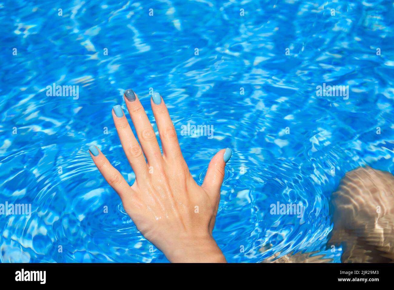 Female hands with bright manicure inside of water Stock Photo - Alamy