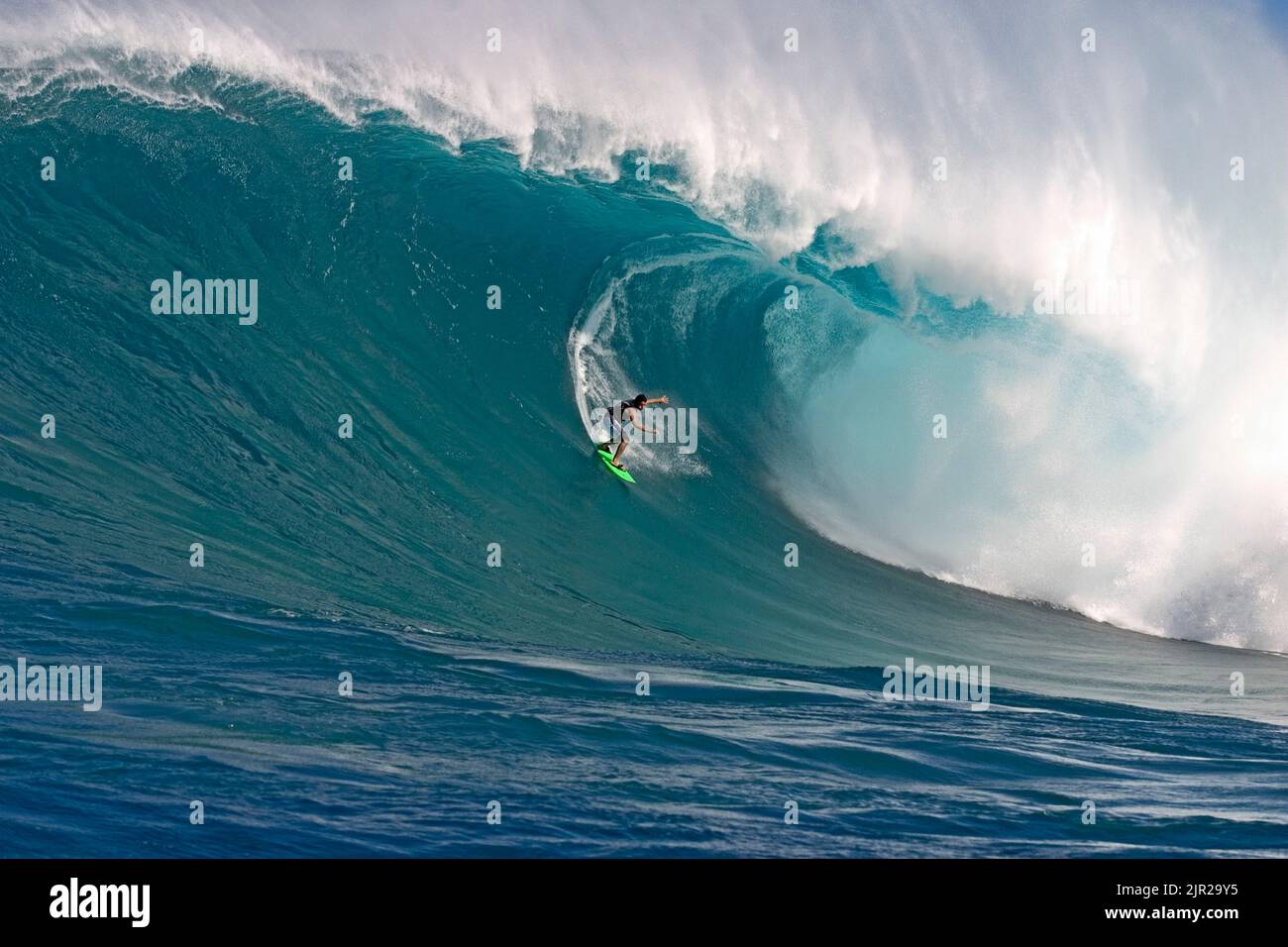 A tow-in surfer drops below the curl of Hawaii's big surf at Peahi ...