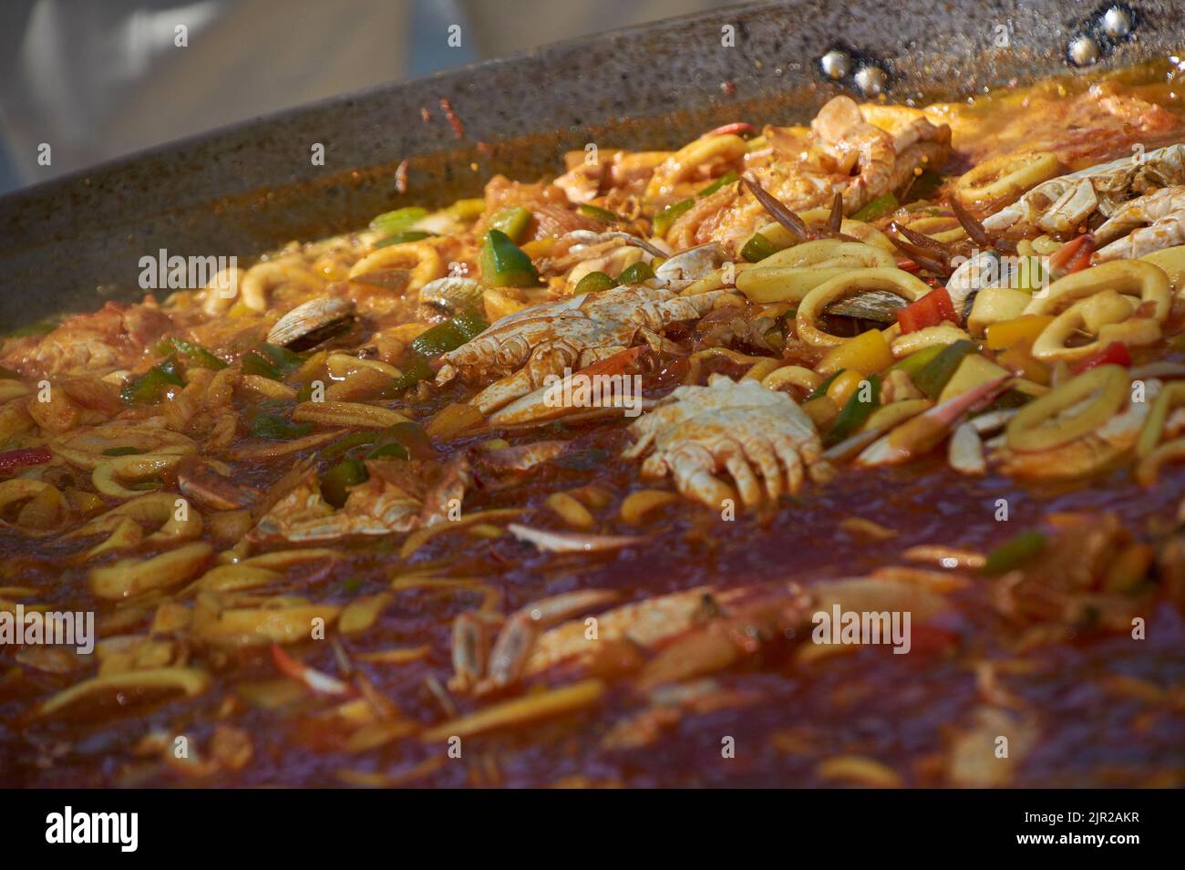 Large pan filled with fish sauce including shellfish, such as crab and ...