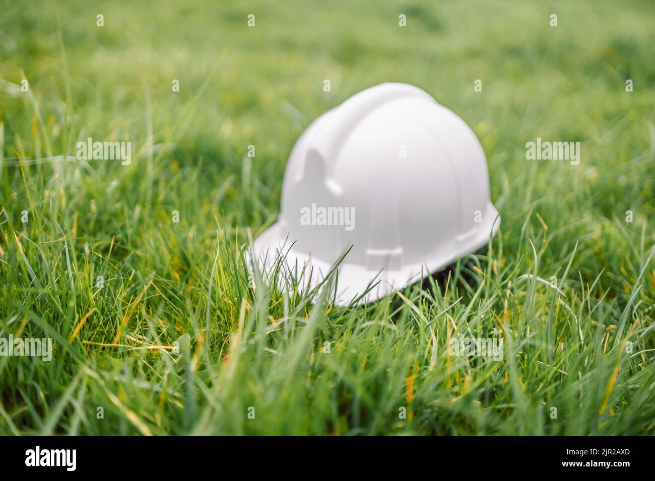 White helmet on green background, save earth engineering concept ...