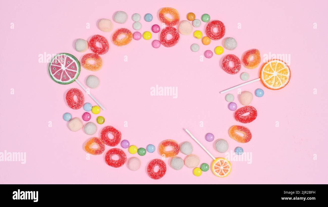 sweet candies and jelly beans make copy space frame on pastel pink ...