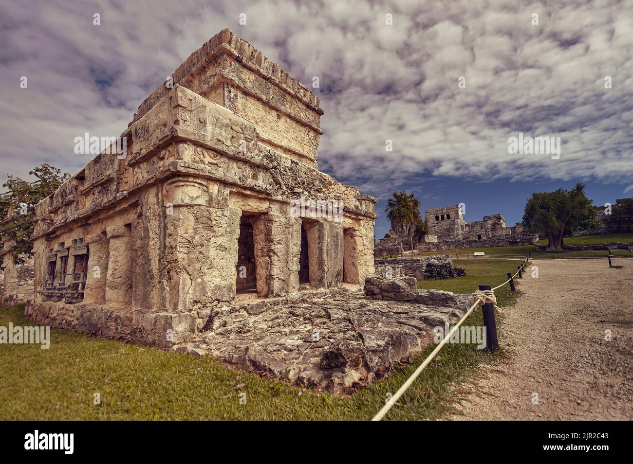 Ruins of Mayan building immersed in a green meadow: View of some parts ...