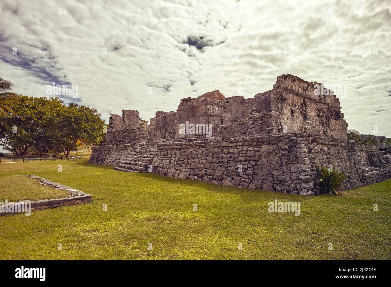 Ruins of Mayan building immersed in a green meadow: View of some parts ...