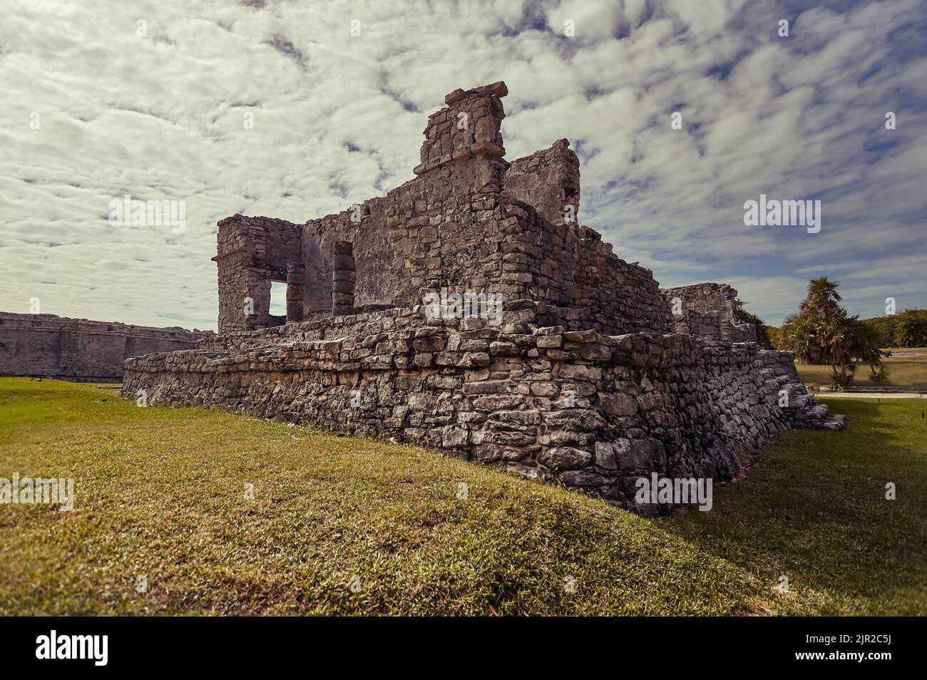 Ruins of Mayan building immersed in a green meadow: View of some parts ...