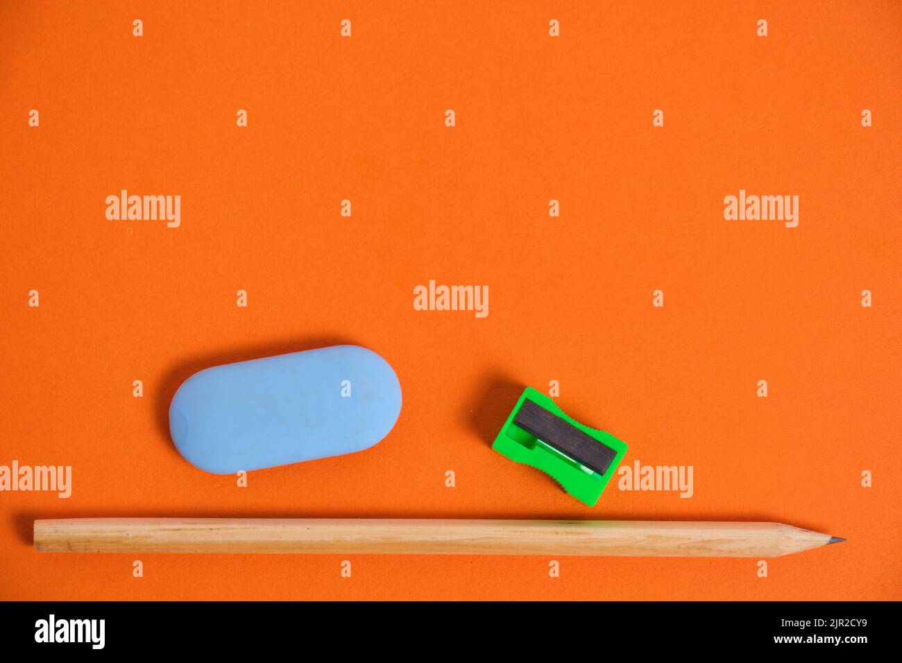 Simple pencil, sharpener and eraser orange background, office and ...