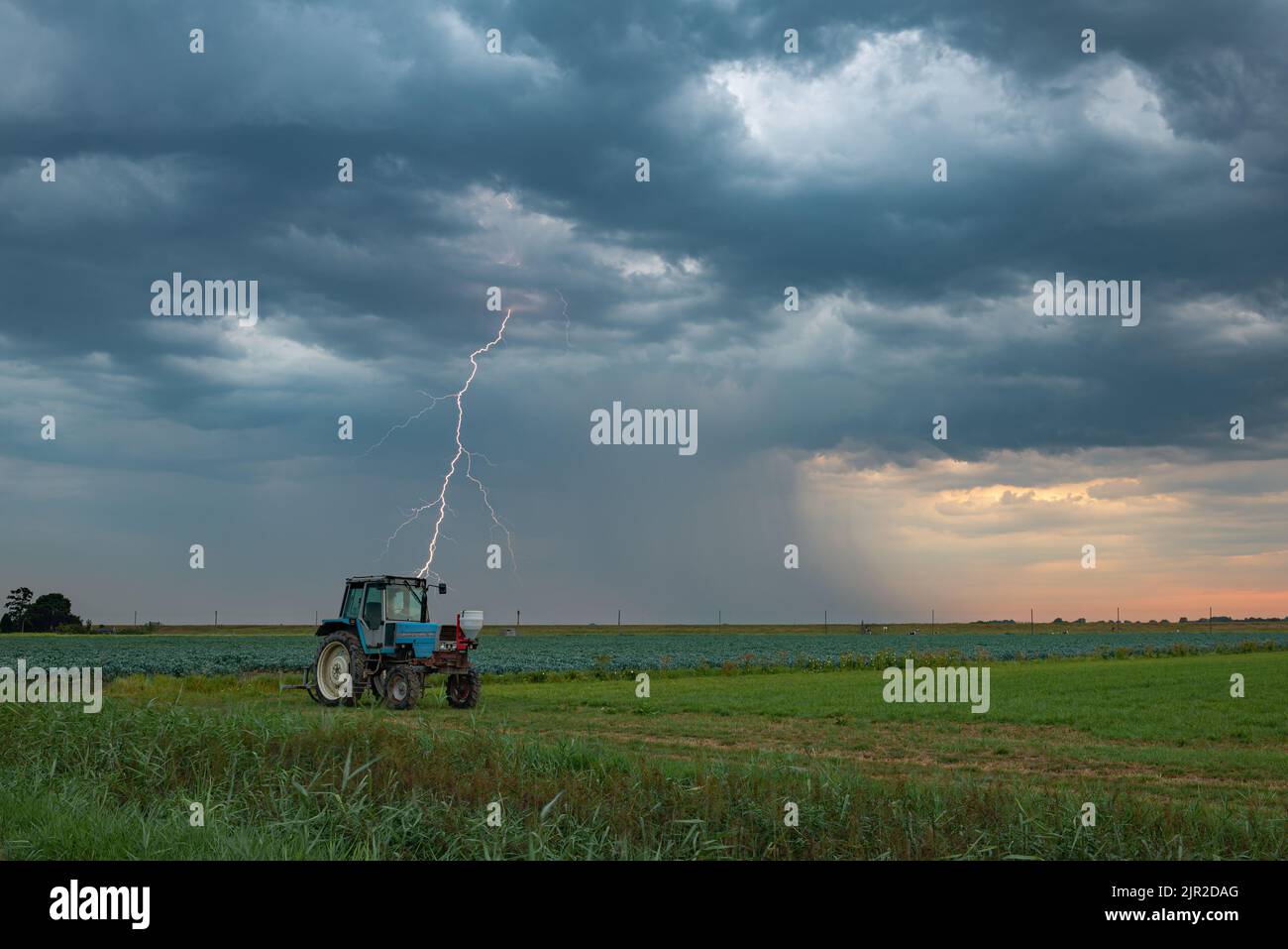 A lightning bolt strikes down from a dramatic stormy sky behind a ...