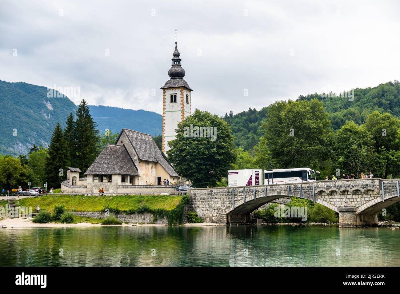 The Janeza Krstnika church building by the Bohinj lake and mountains ...