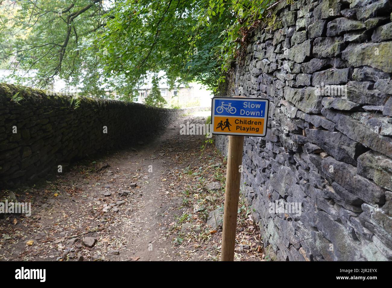 A notice warning cyclists to slow down on account of children playing ...
