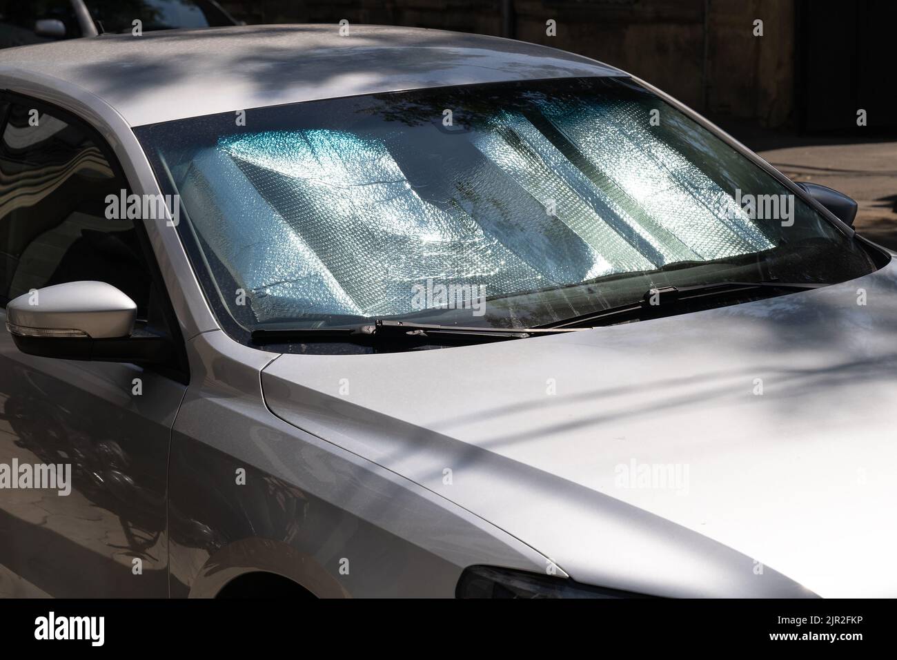 Protective reflective surface under windshield of car on hot day ...