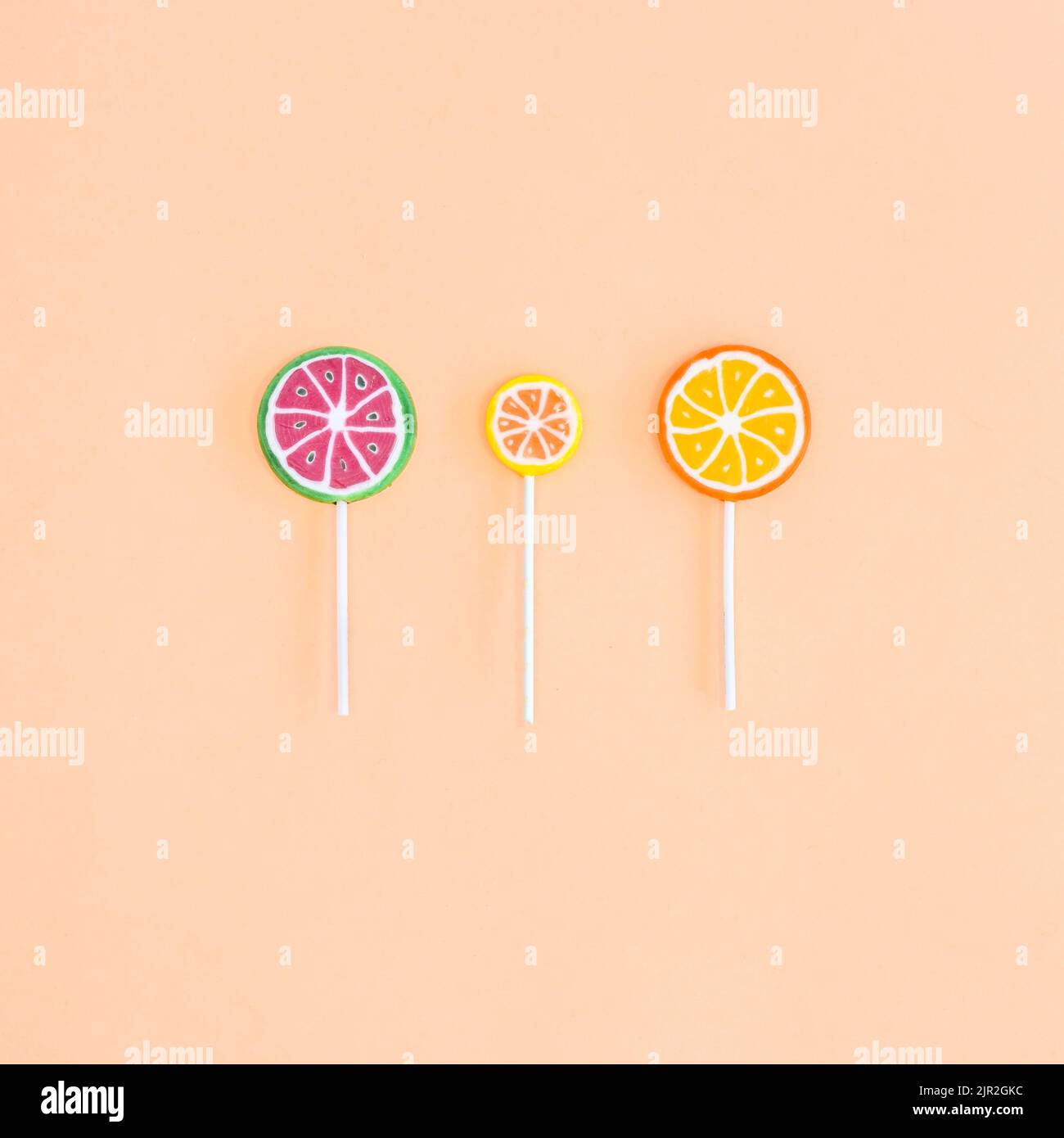 Three fruity lollipops on beige background. Flat lay Stock Photo - Alamy