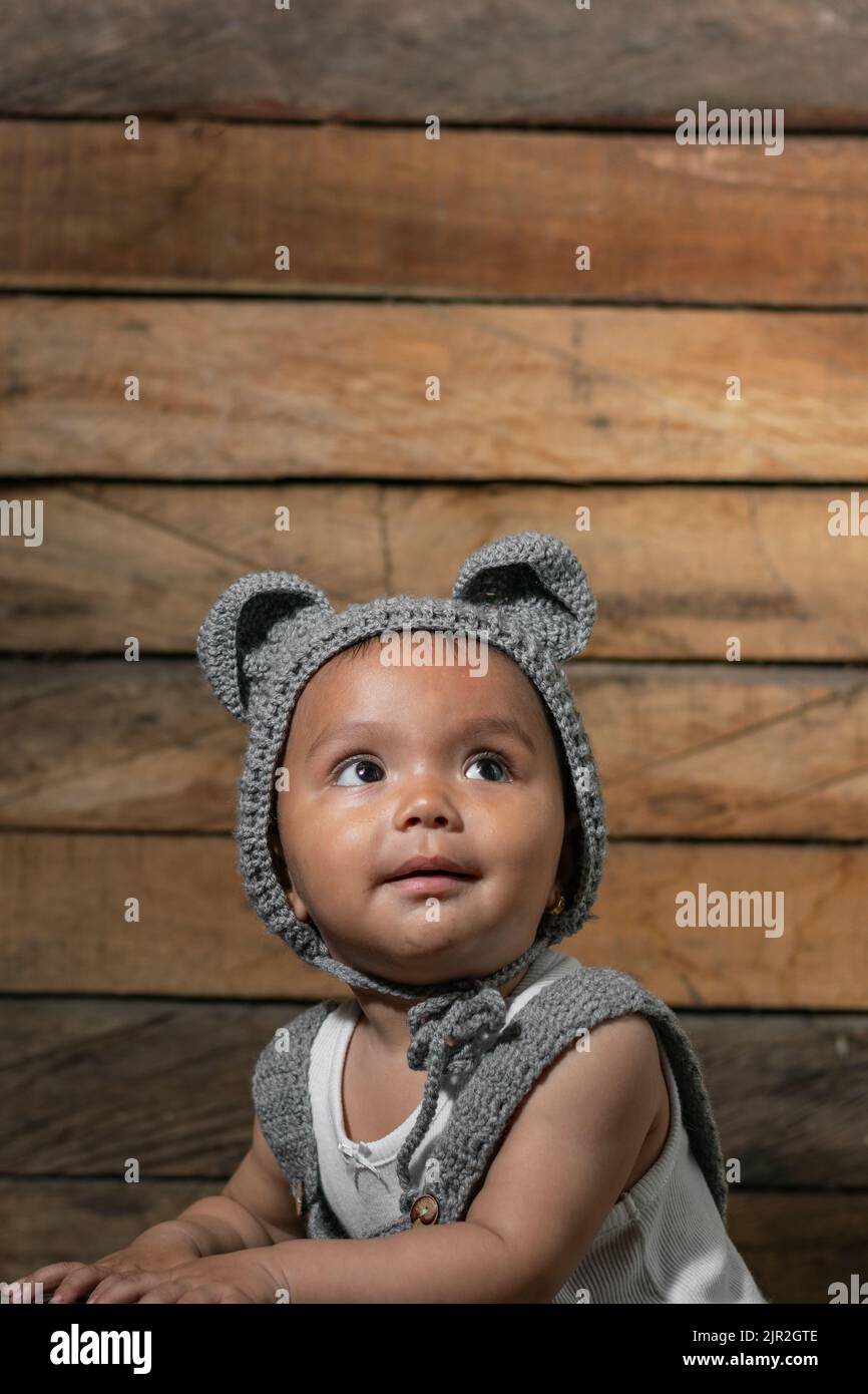 vertical photo of a beautiful latin baby girl with brown skin, wearing ...