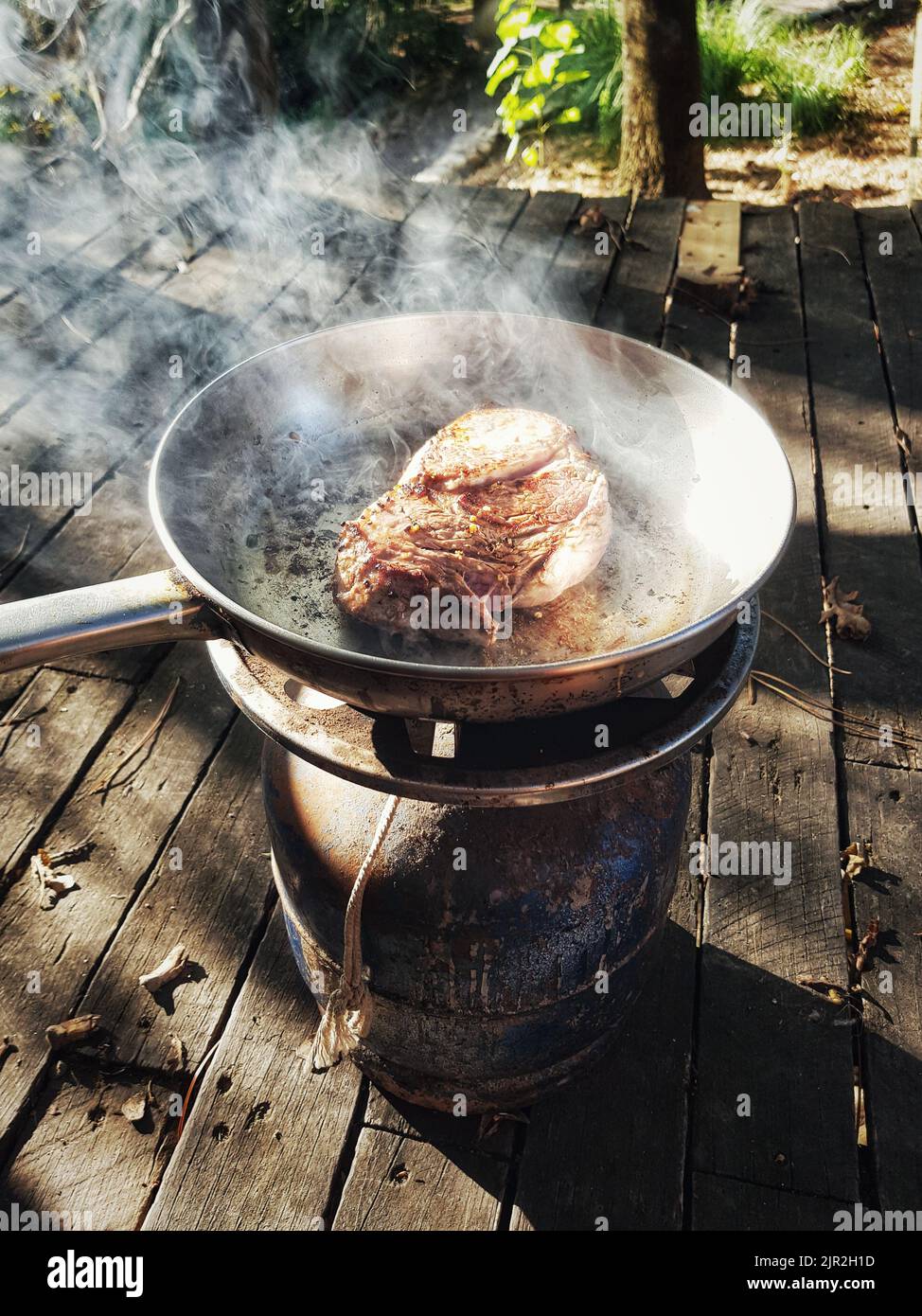 A vertical shot of cooking meat on a pan on a Gas Tank Stock Photo - Alamy