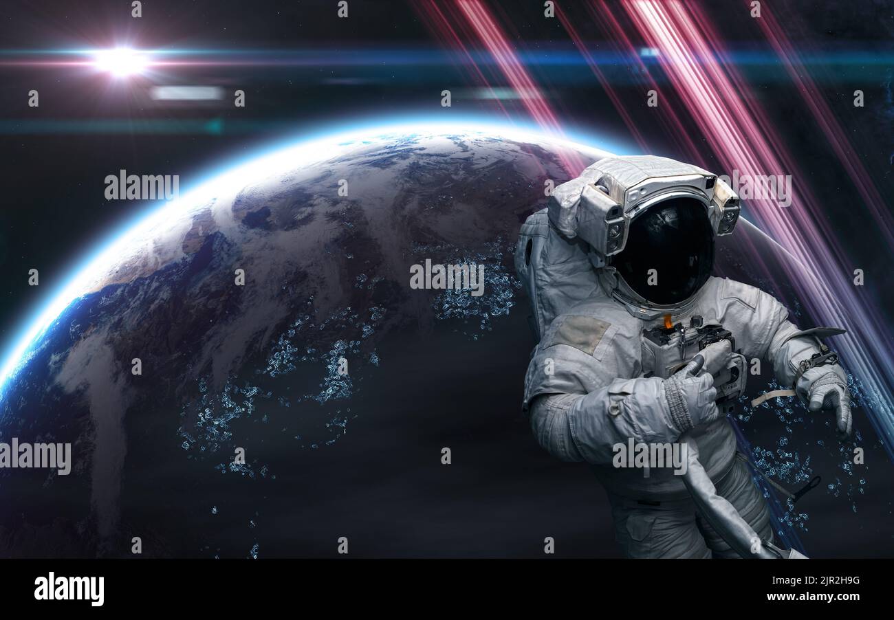 Astronaut in outer space. Distant habitable planet in light of bright ...