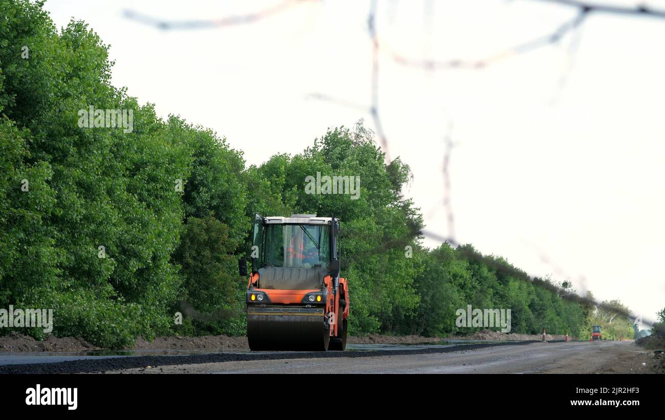 Road construction works with roller compactor machine and asphalt ...