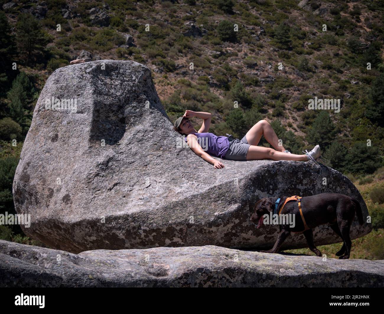 Female dog owner resting on a granite boulder with sofa shape and ...
