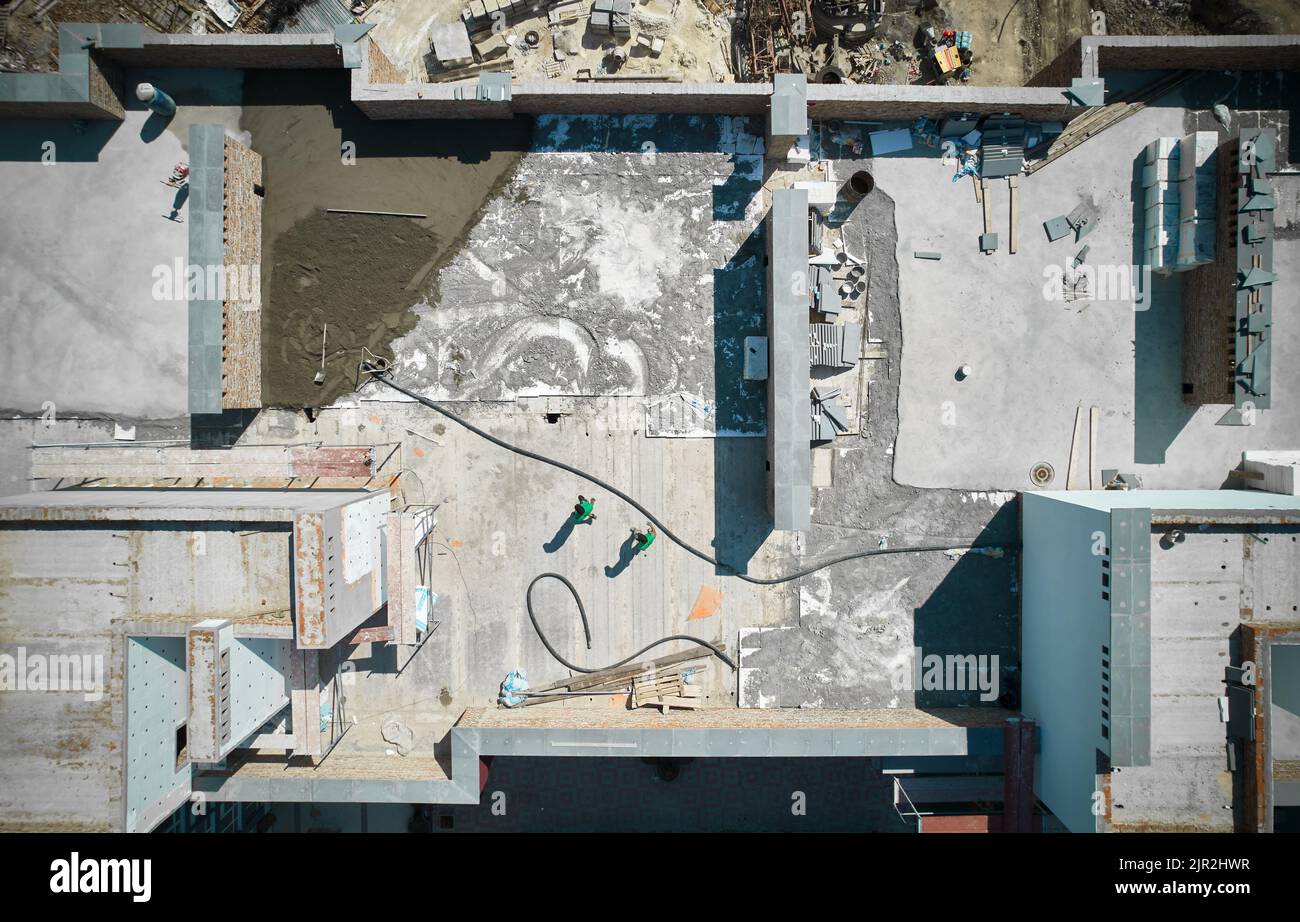 Top view of construction site with workers, building materials, brick ...
