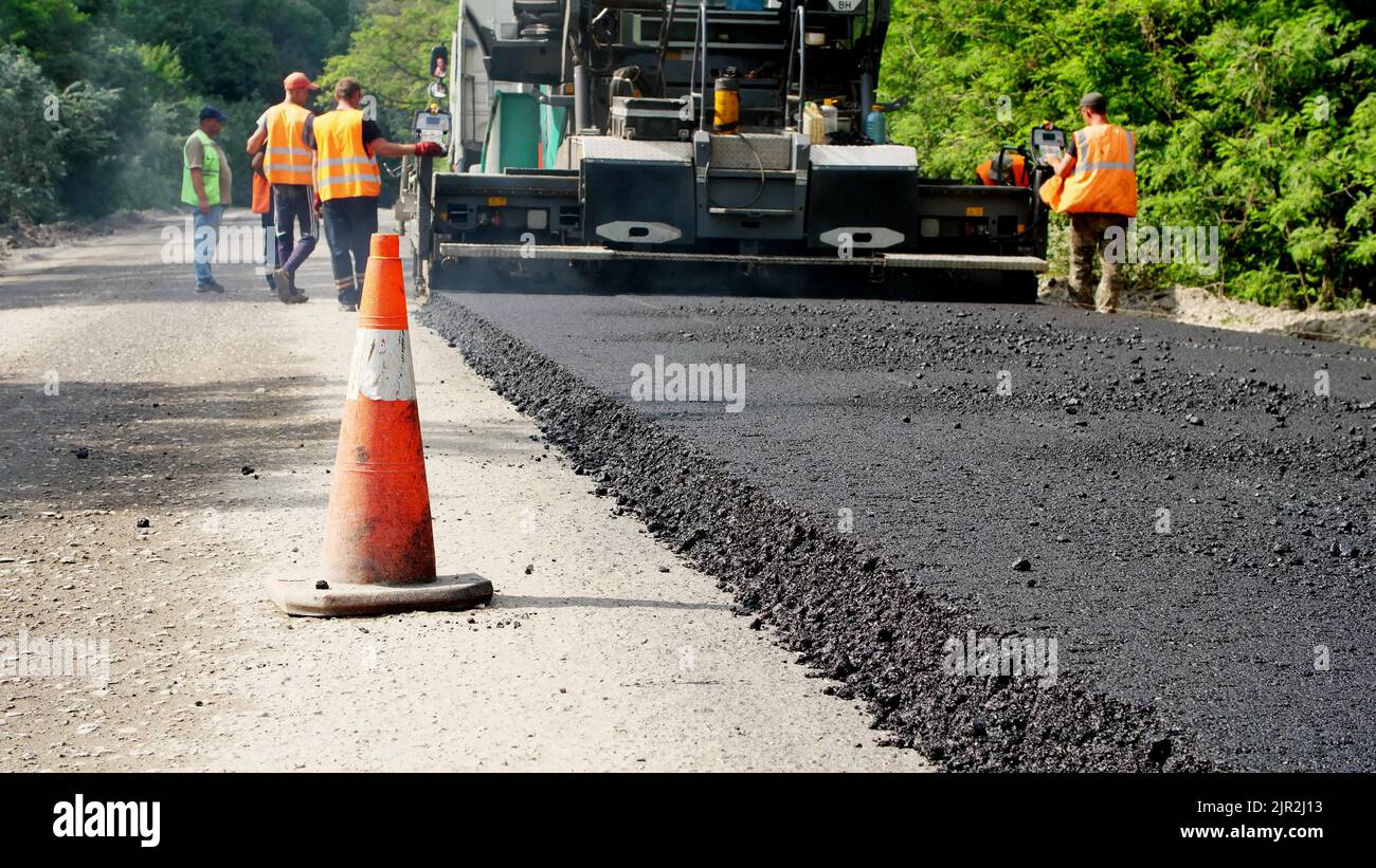 Repair of a highway, Road construction works. workers lay asphalt ...