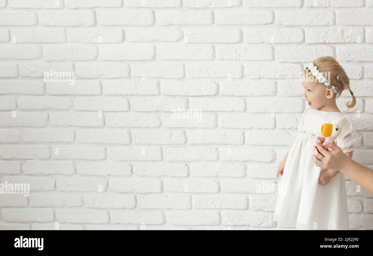 Banner child with hearing aids and cochlear implants on white brick ...