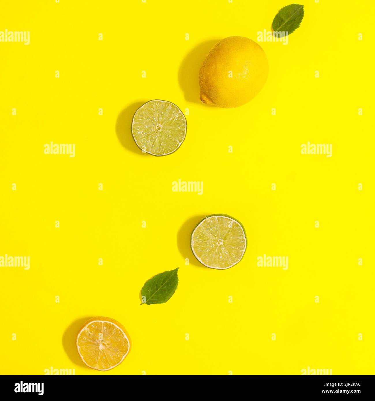 Fresh sliced lemons and limes arrangement on yellow background. Flat ...