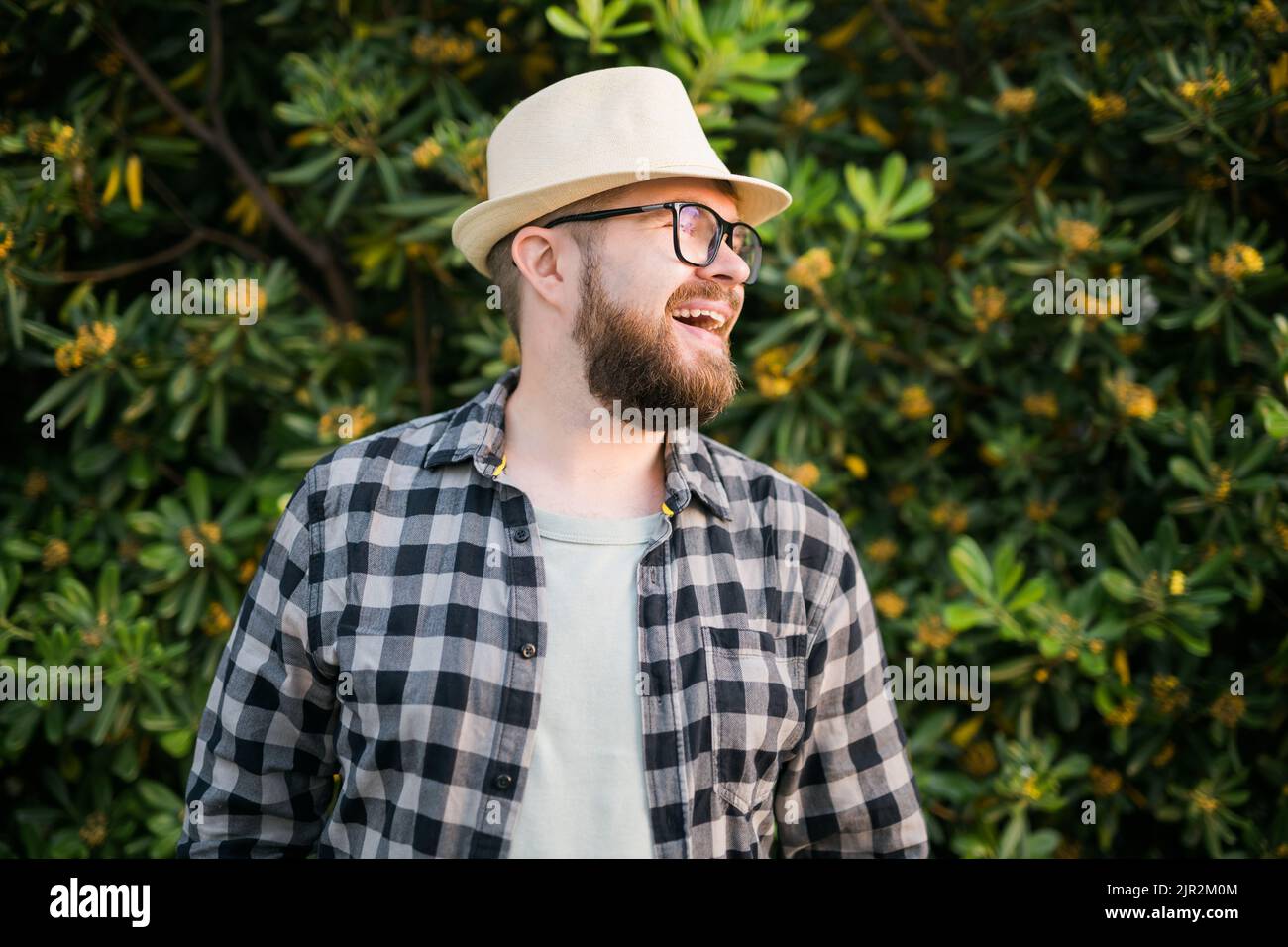 Portrait handsome laugh man over green bush outside - summer and ...