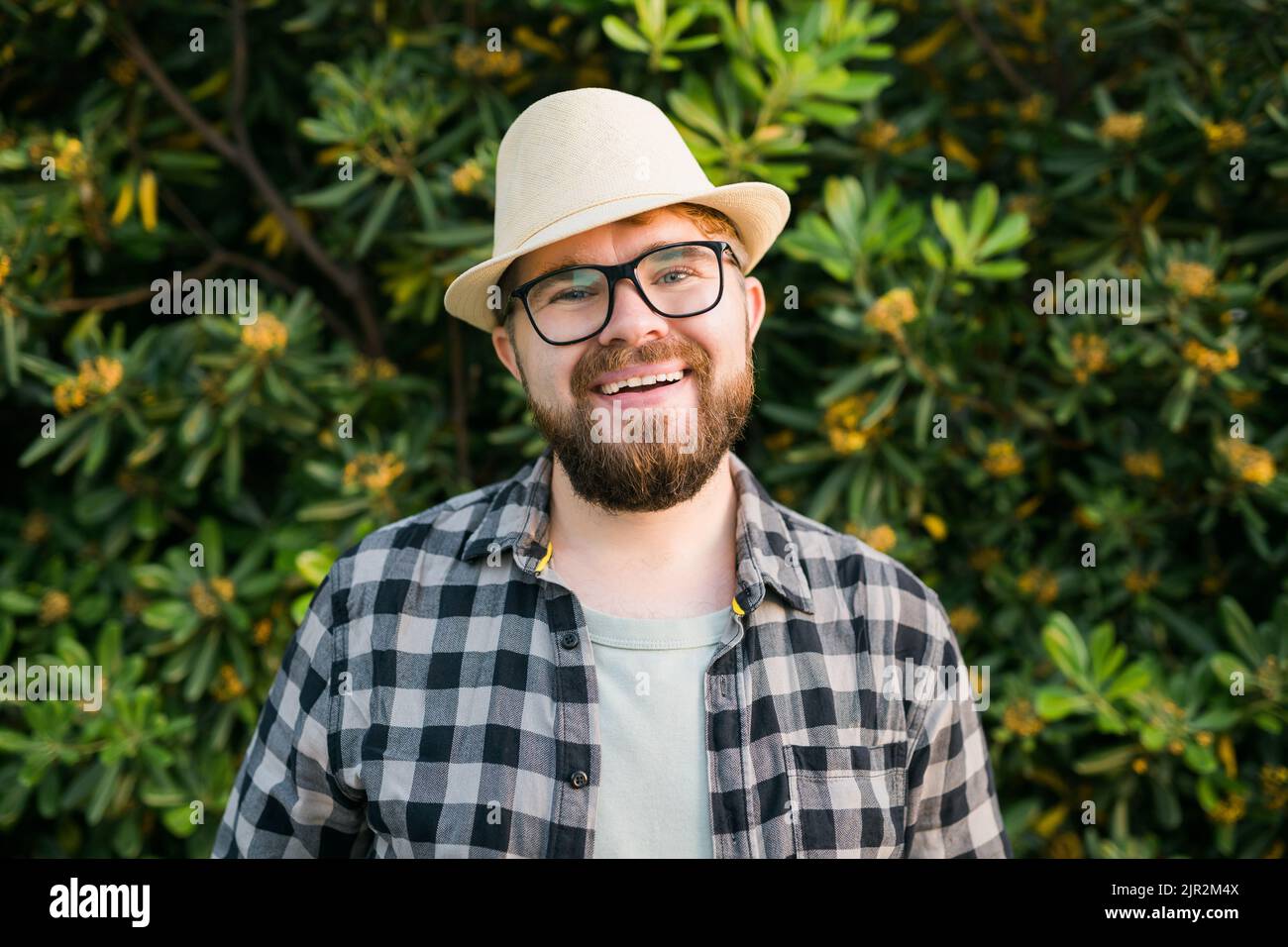 Portrait handsome laugh man over green bush outside - summer and ...