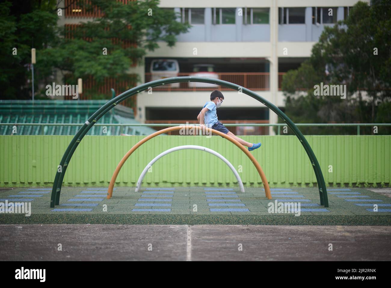 A closeup shot of a boy doing exercise in playground with colorful ...