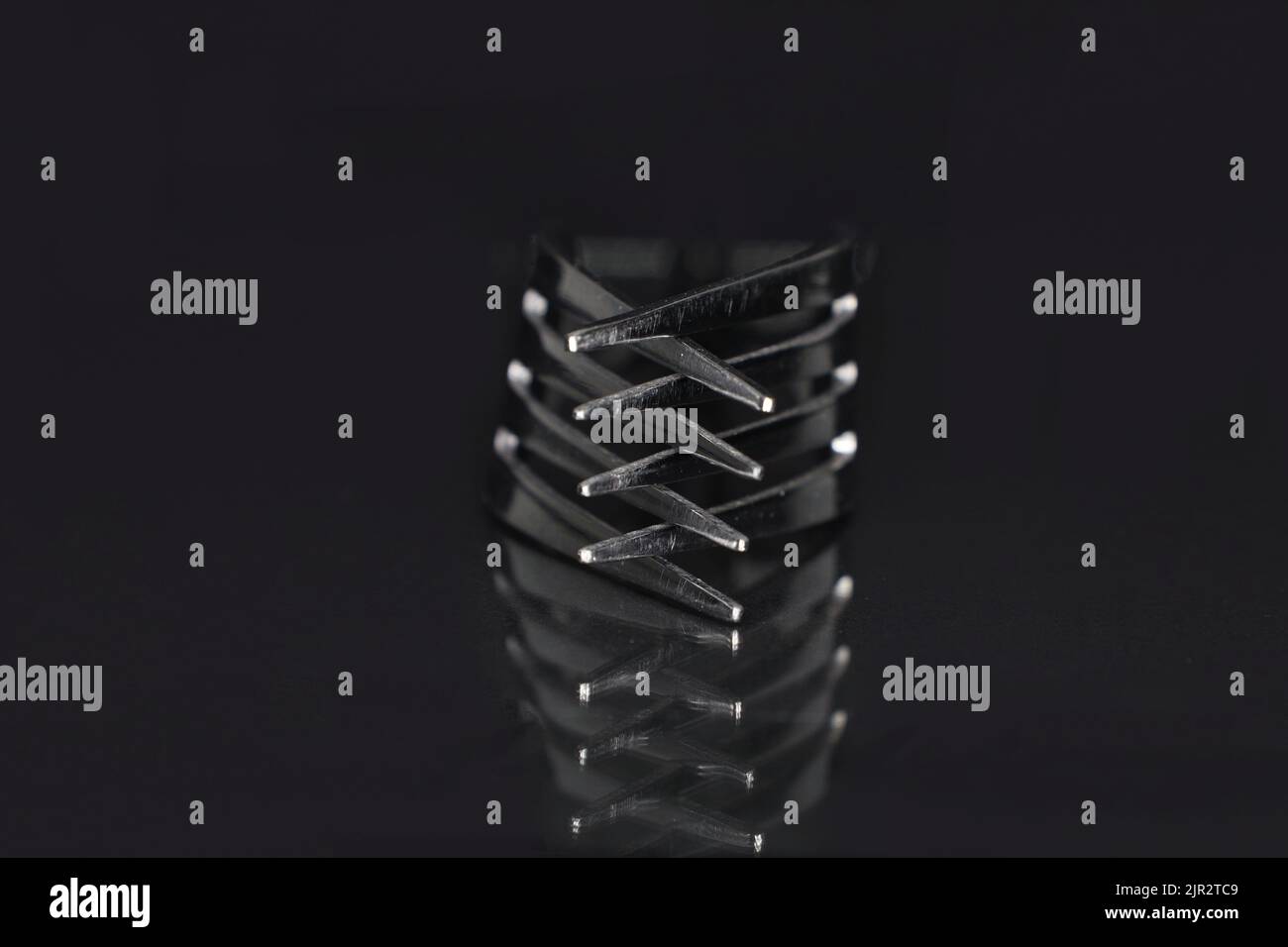 The crossed tines of stack of silver forks on black background Stock ...