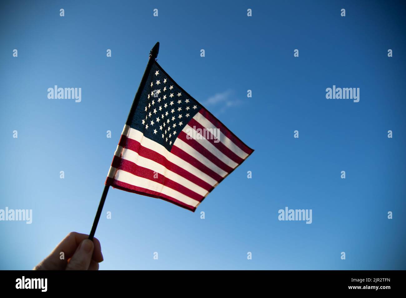 Hand holding American flag. National symbol of the United States of ...