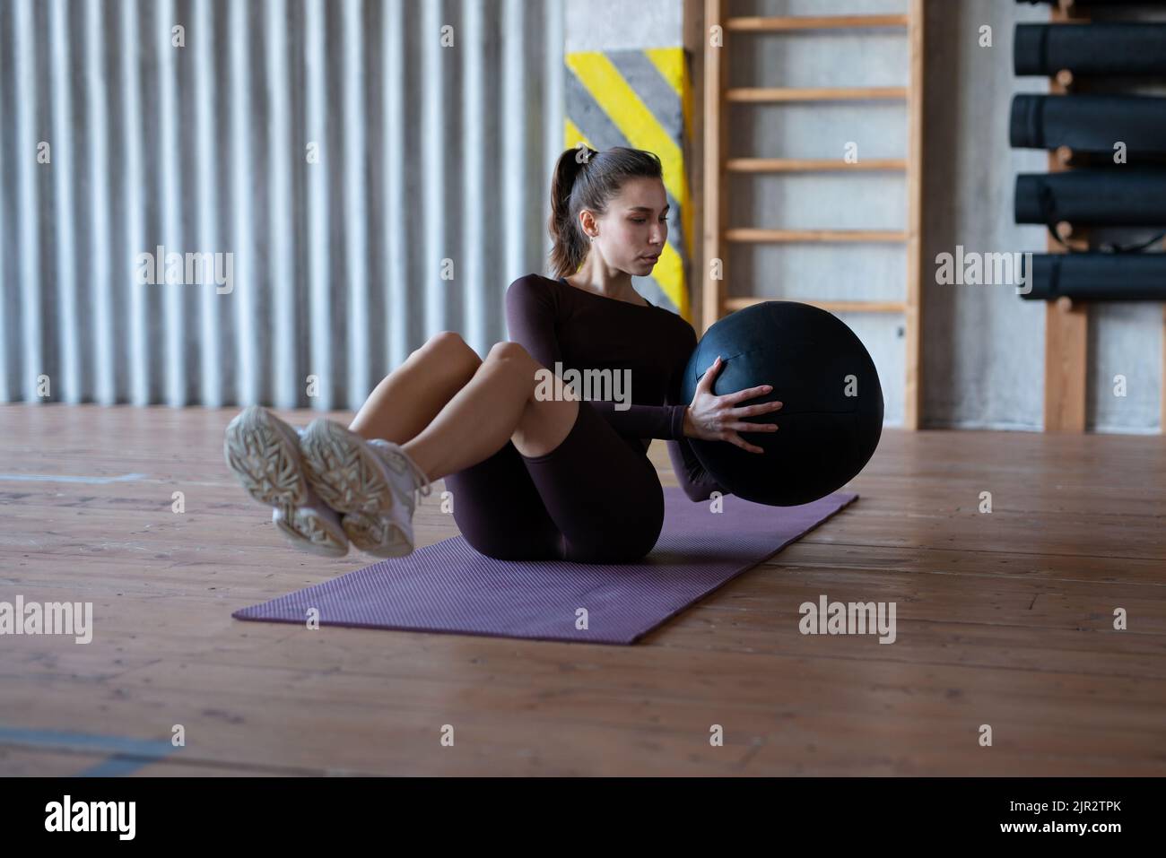 Fit young woman exercising with medicine ball, female athlete doing abs ...