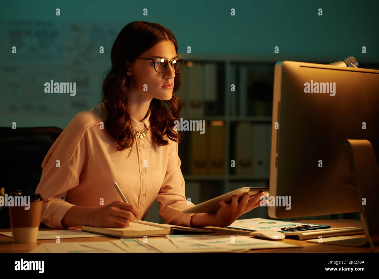 Female financial analyst working on financial report at her table Stock ...