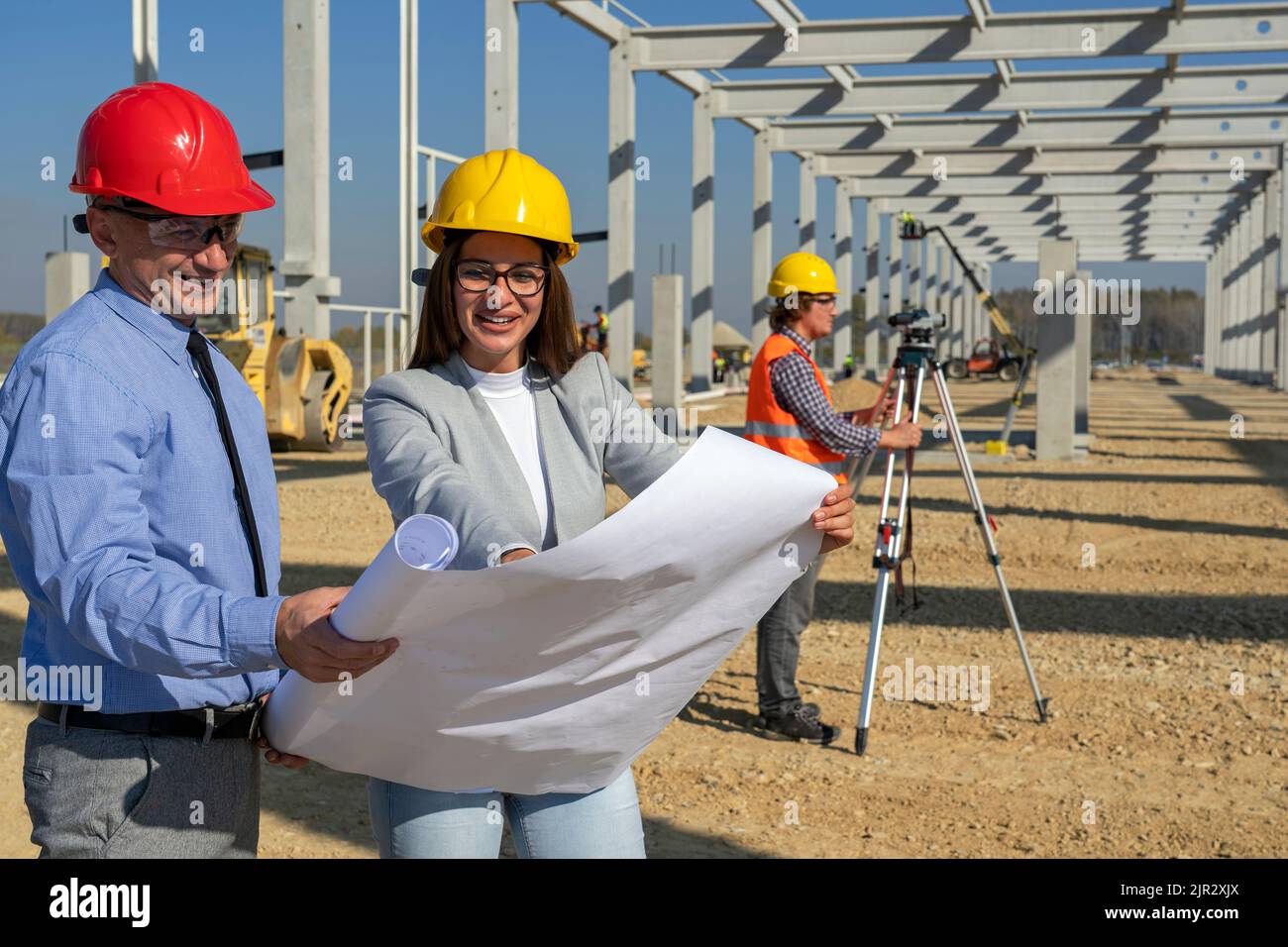 Man And Woman In Hardhats Disscus A Construction Project. Gender ...