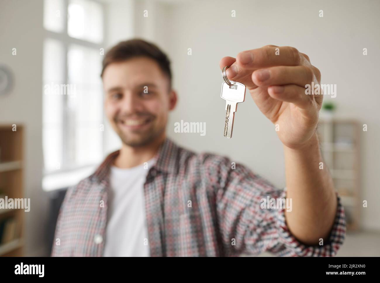 Real estate background with a happy homeowner holding and showing the ...