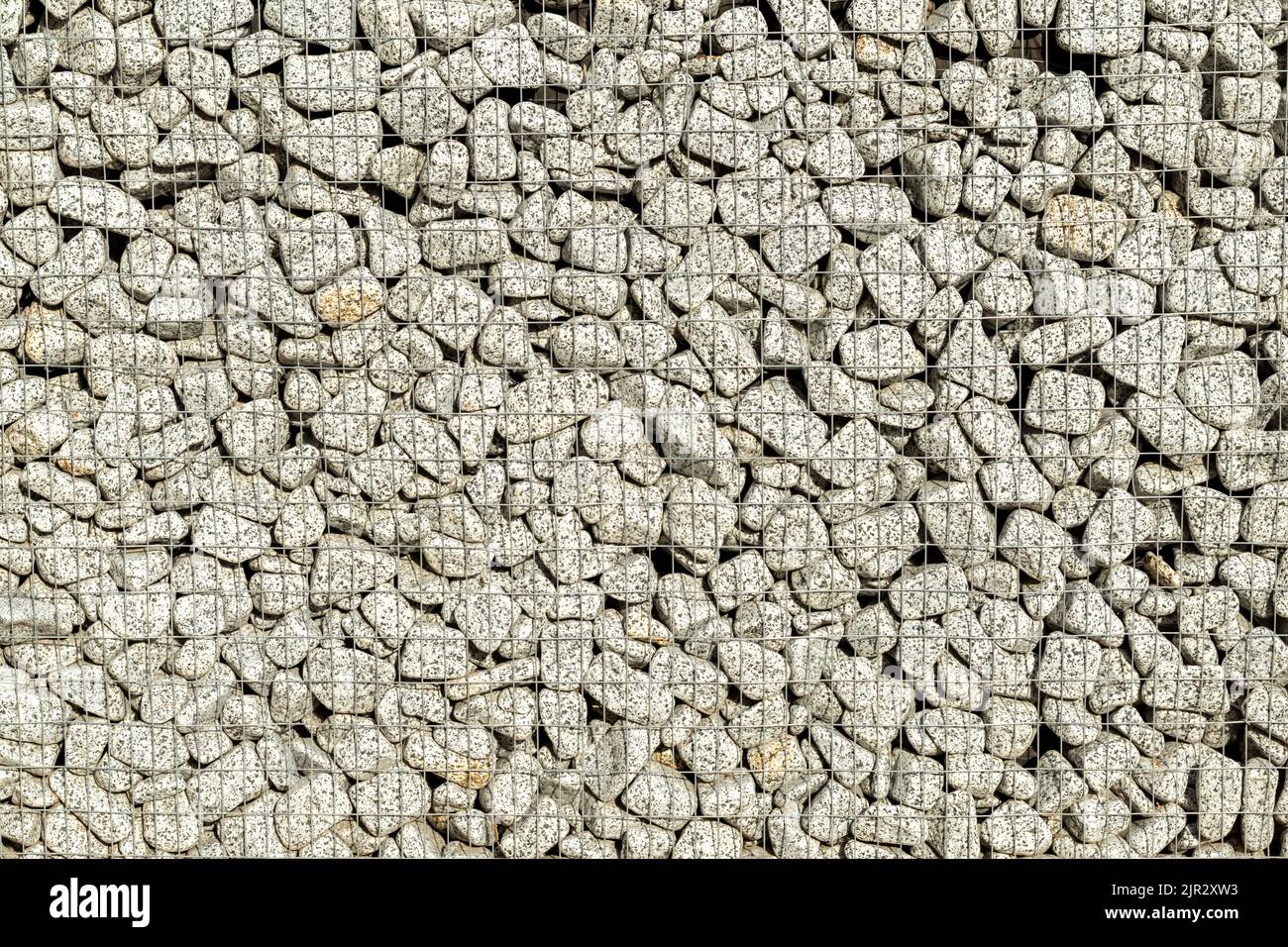 Stone wall in wire frame. Textured background of a stone wall with iron ...