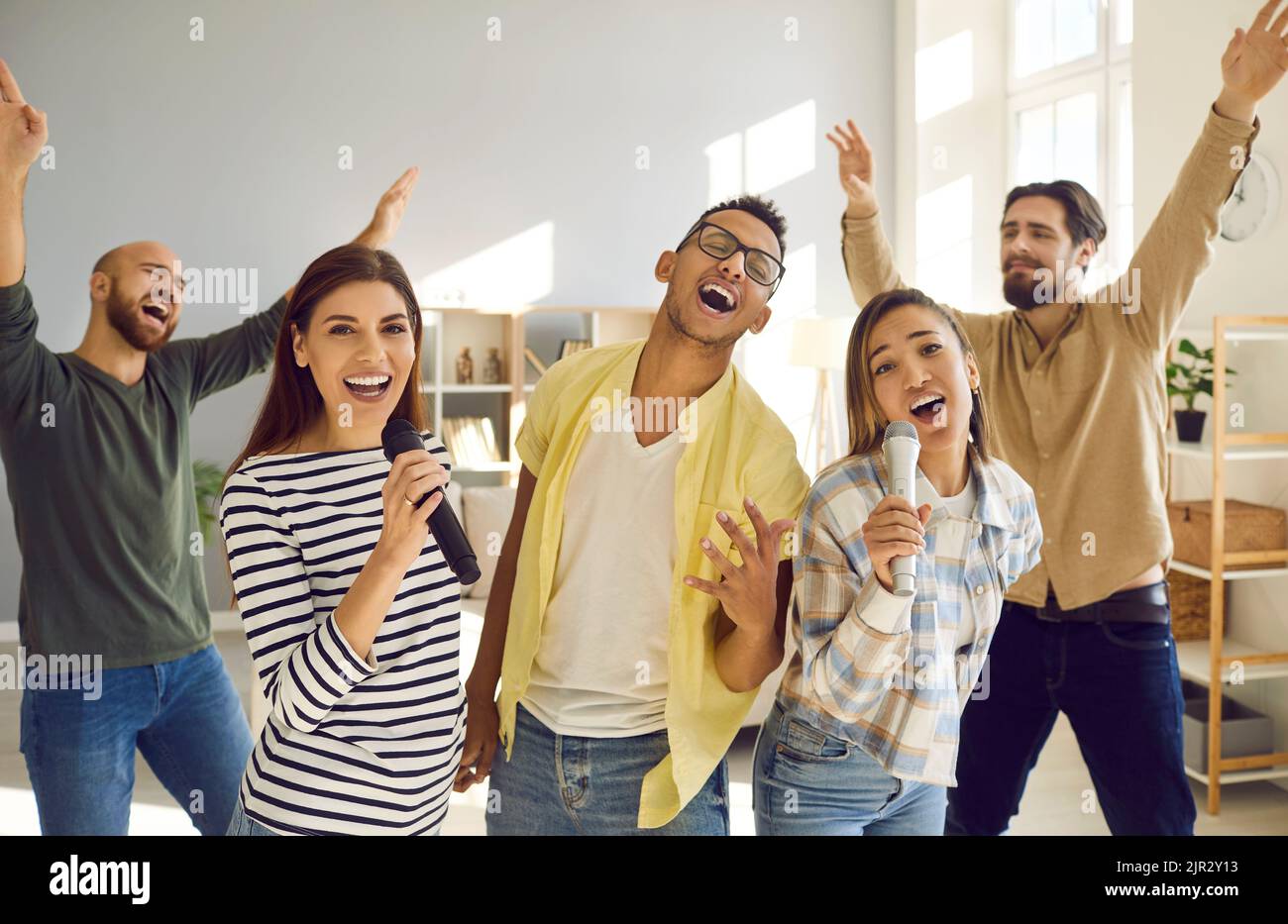 Happy diverse friends have fun singing karaoke Stock Photo - Alamy