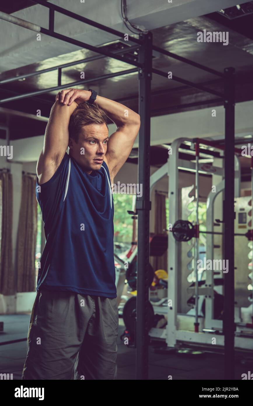Fit young man stretching arms after working out Stock Photo - Alamy