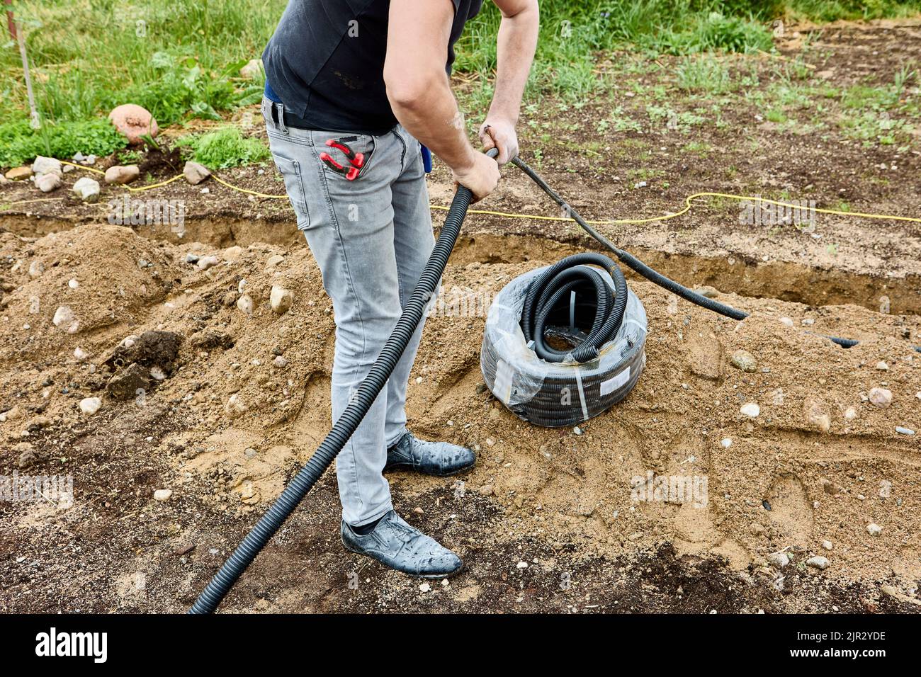 Outdoor cable work, cableman lays power cable in trench Stock Photo - Alamy