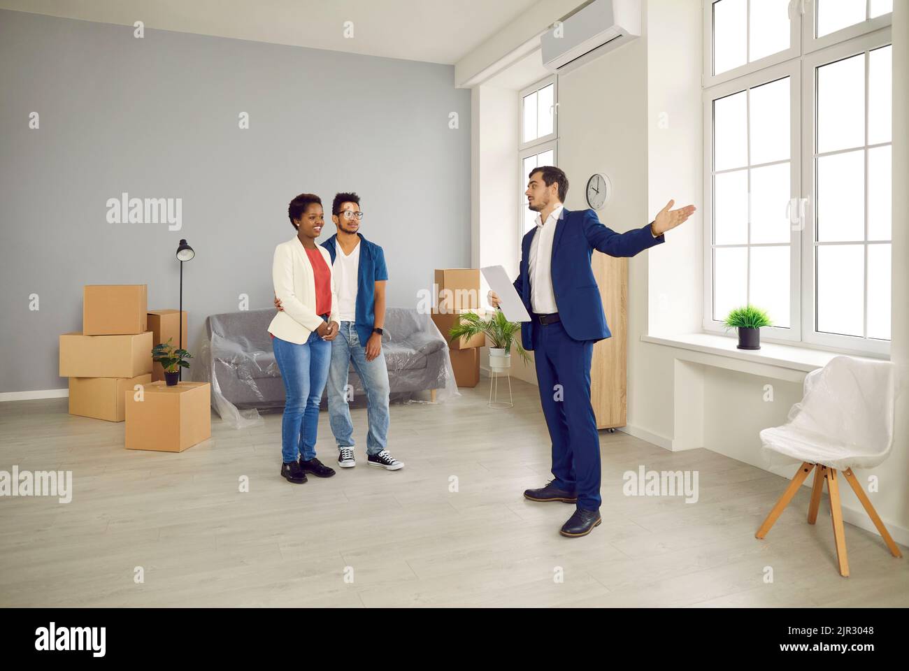 Realtor giving tour around the house to young couple who are planning ...