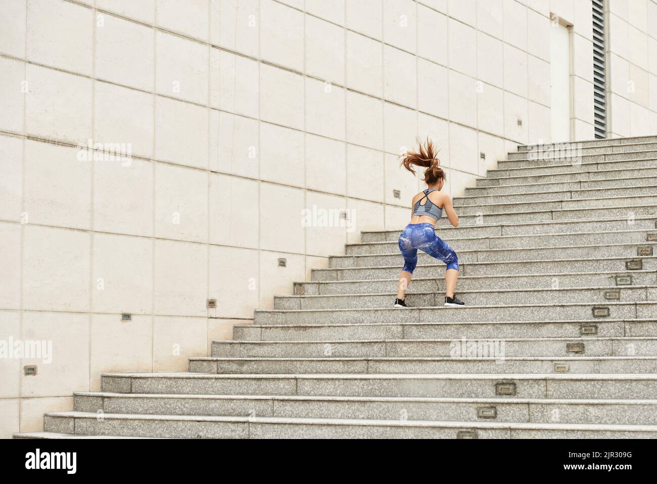 Fit young woman jumping up the stairs to strenghten her legs Stock ...