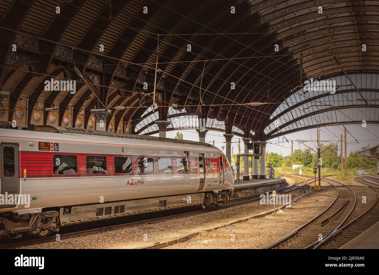 A train rests beneath a historic 19th century railway station canopy ...