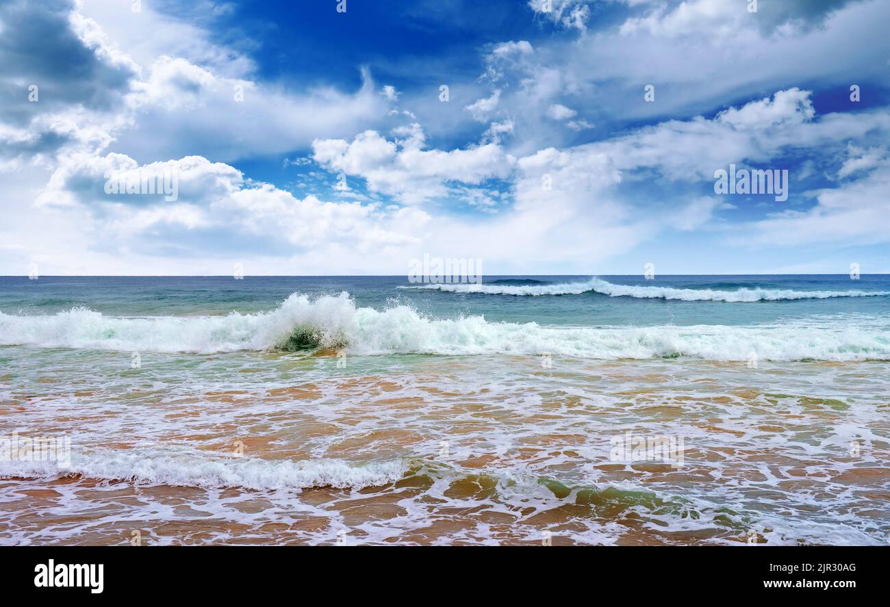 Bright seascape with white clouds, blue sky and beautiful sea surf ...
