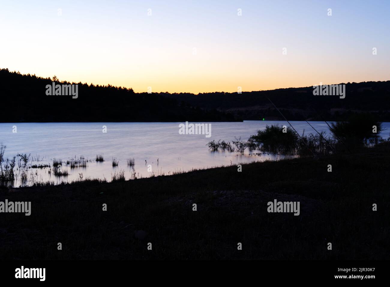 Sunset at lakeside and hills at the background Stock Photo - Alamy