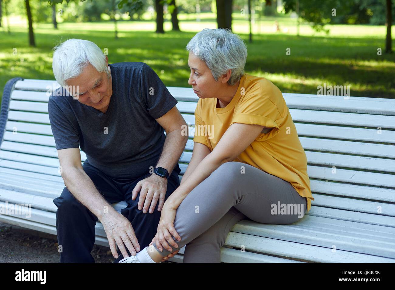 During morning stroll, sportive exercises in park, elderly 60s woman ...