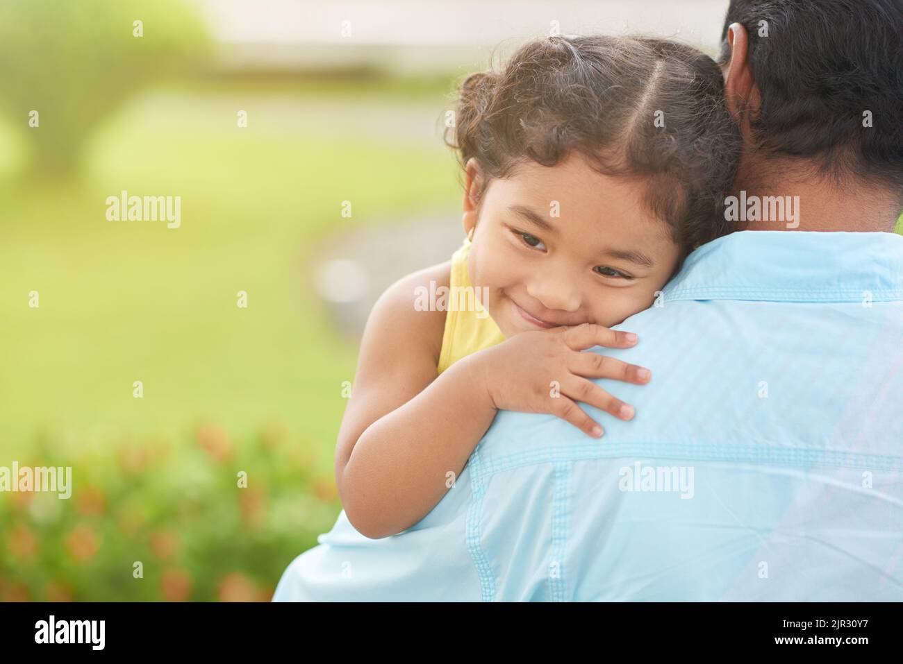 Smiling cute little girl resting on shoulder of her father Stock Photo ...