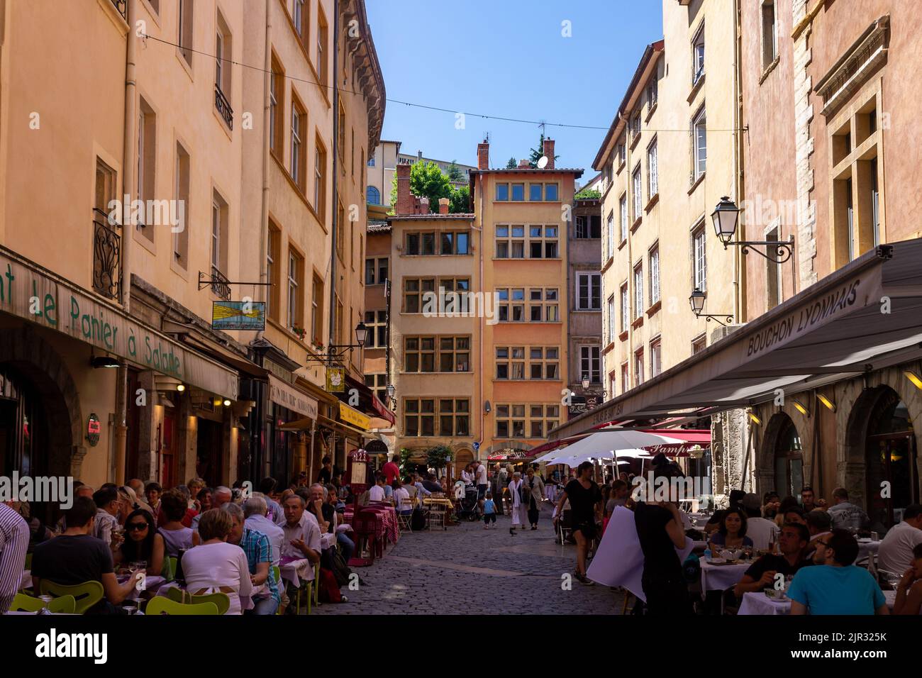 A small downtown street in Lyon France with old buildings and cafes ...
