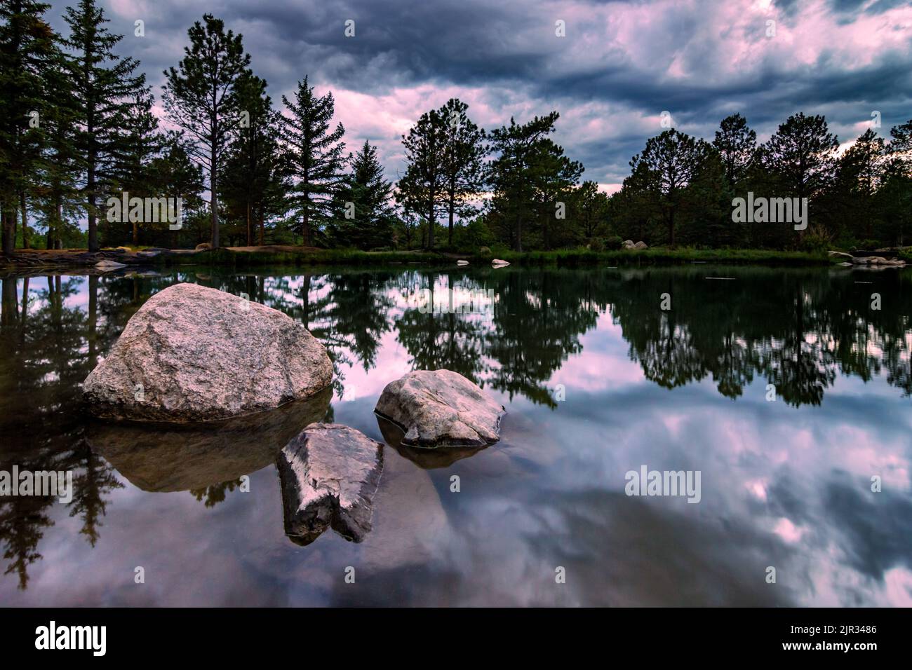 Granite boulders form stepping stones into the perfect reflection of ...