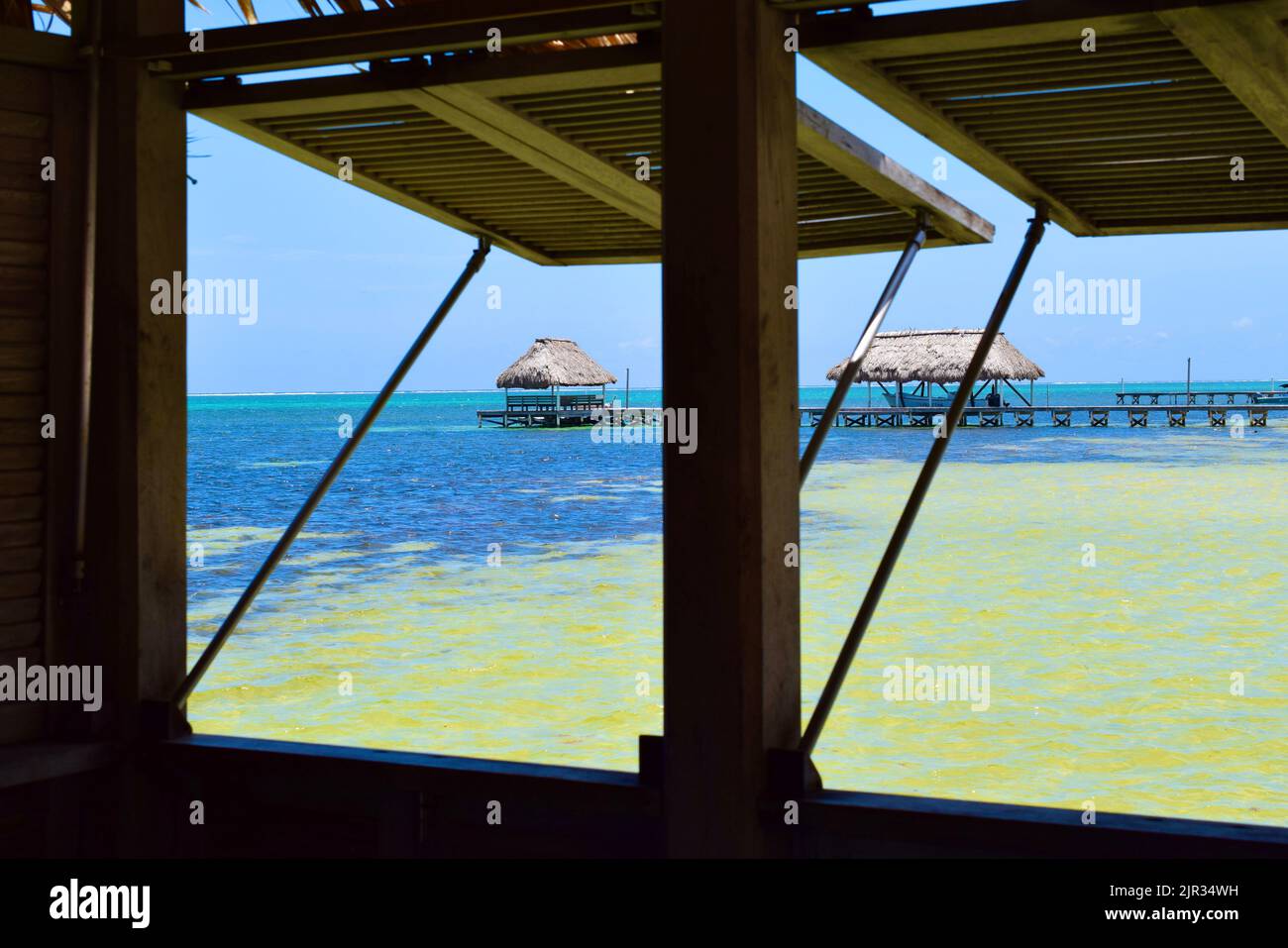 The view from inside a palapa hut of the water, a pier, and some ...