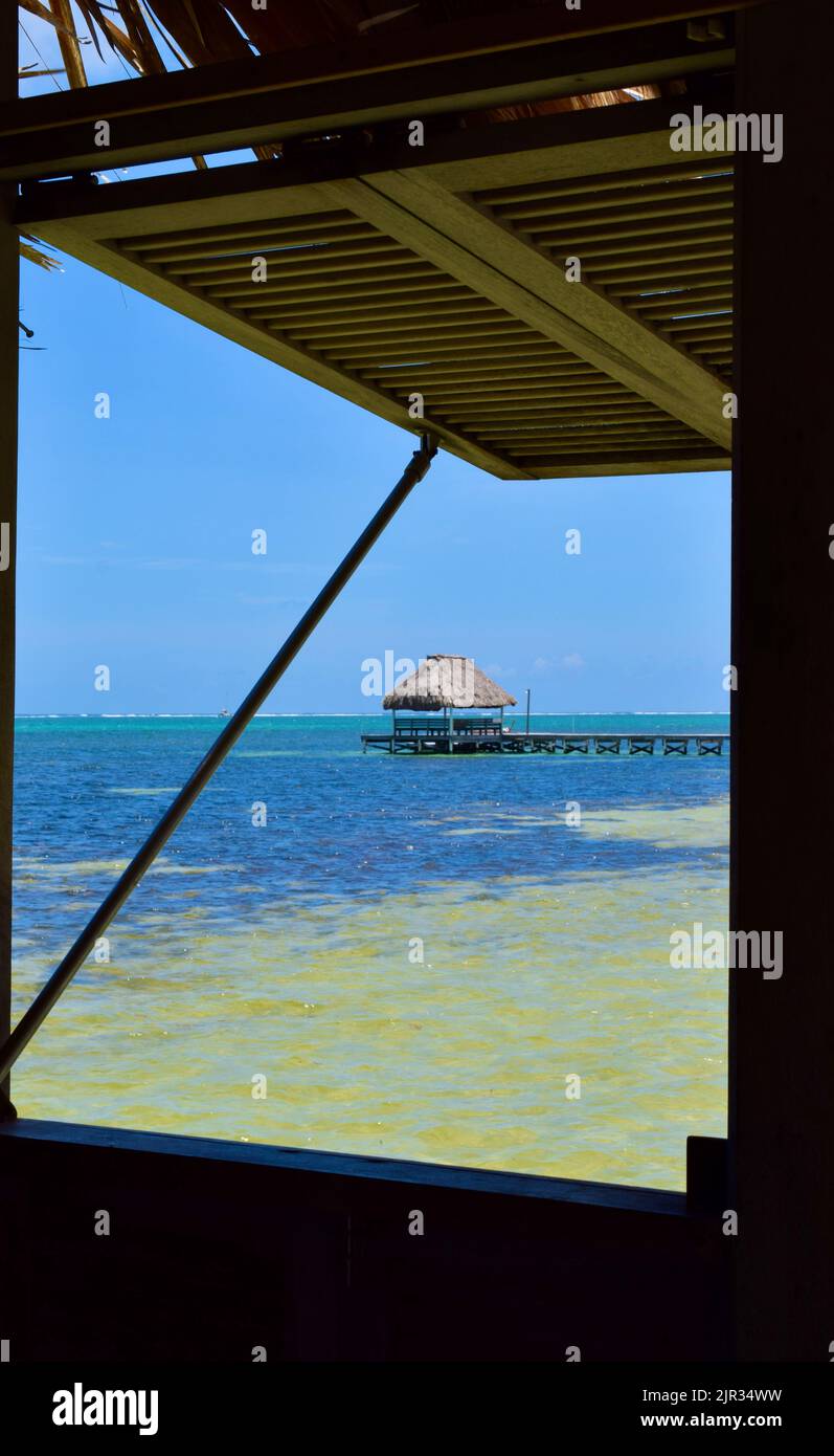 The view from inside a palapa hut of the water, a pier, and some ...